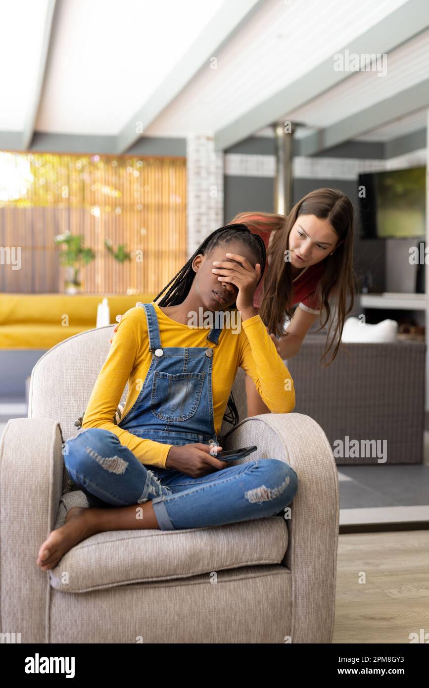 Sad diverse teenager girls friends sitting in armchair, cheering up ...