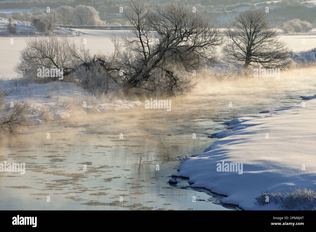 River Whiteadder in early morning light with steam rising from surface ...