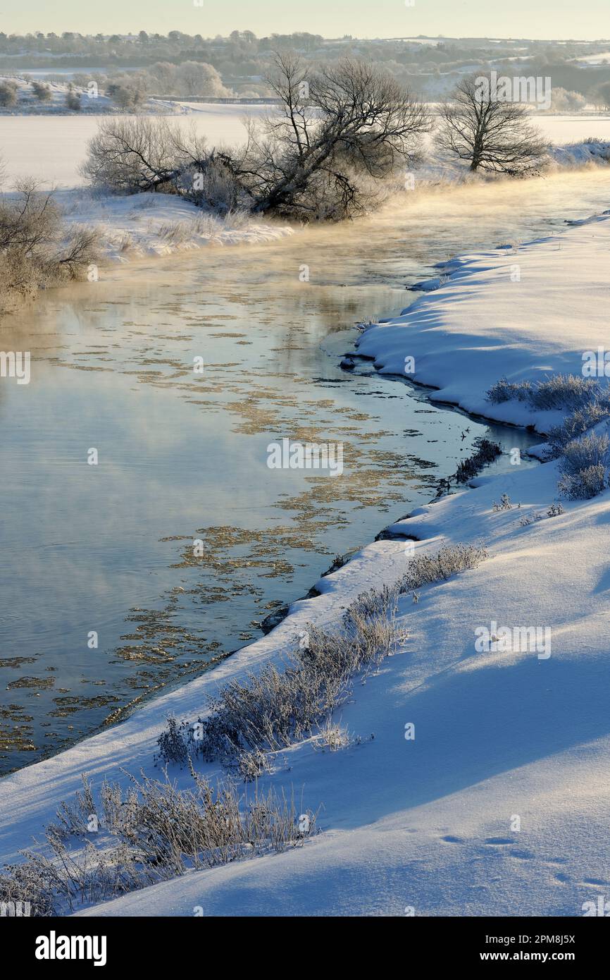 River Whiteadder in early morning light with steam rising from surface ...