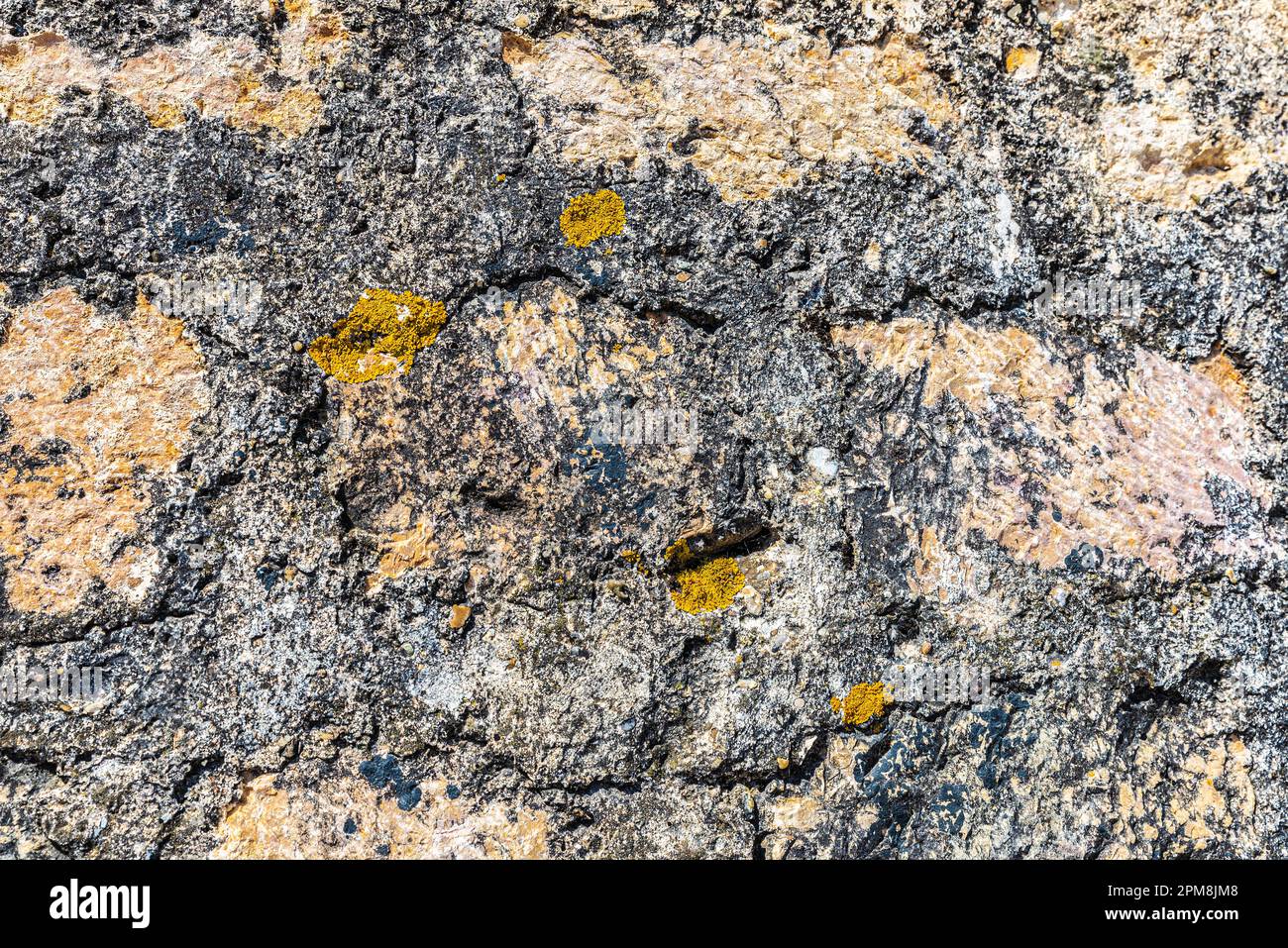 Eroded stone wall with lichen as background Stock Photo - Alamy