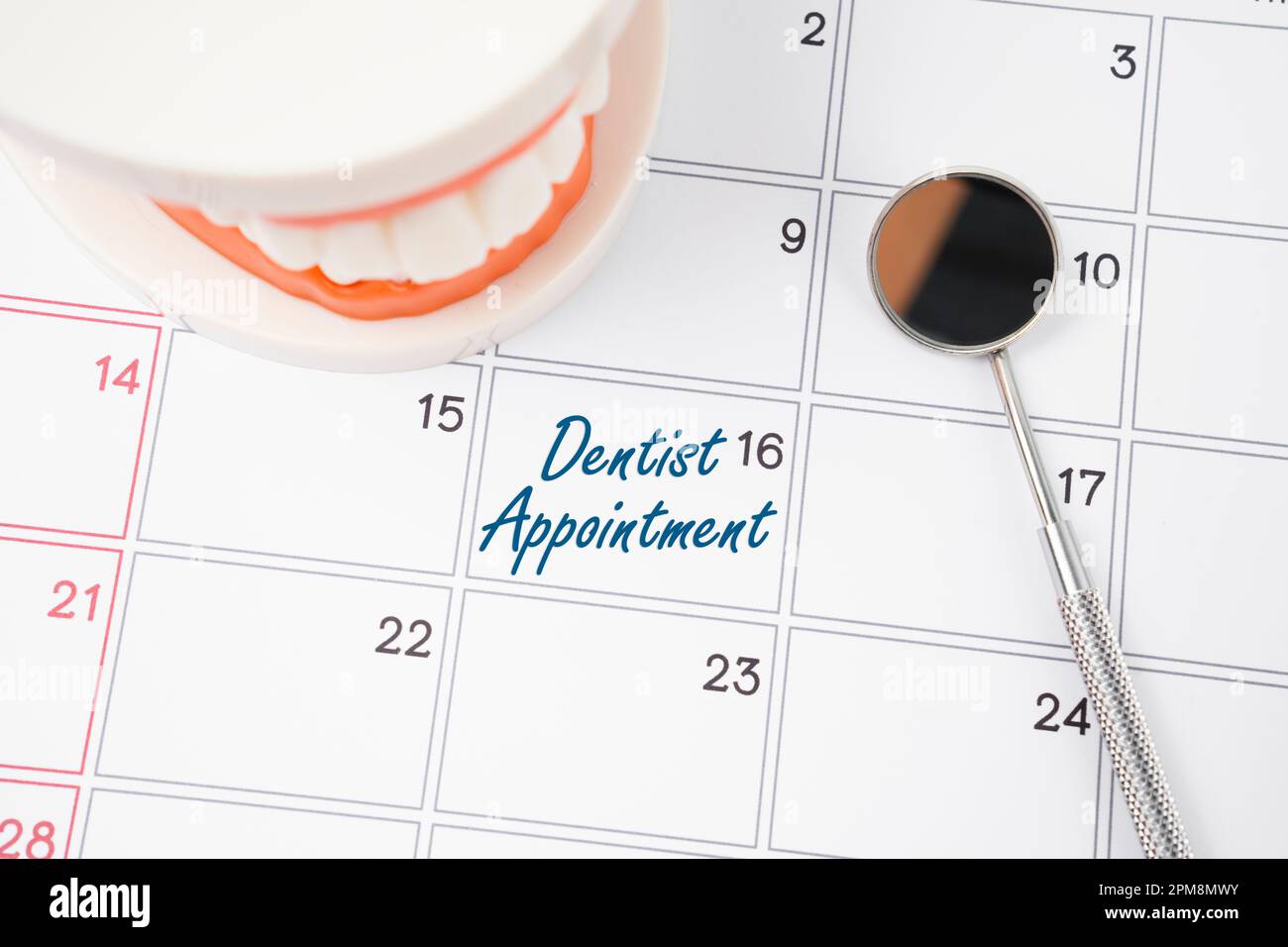 Dentist appointment writing on a calendar page and dentures model with ...