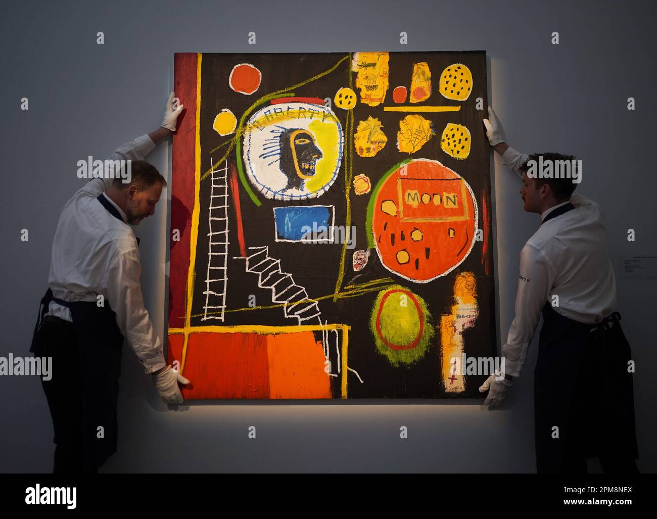 Gallery technicians holding a painting by Jean-Michel Basquiat, Moon ...