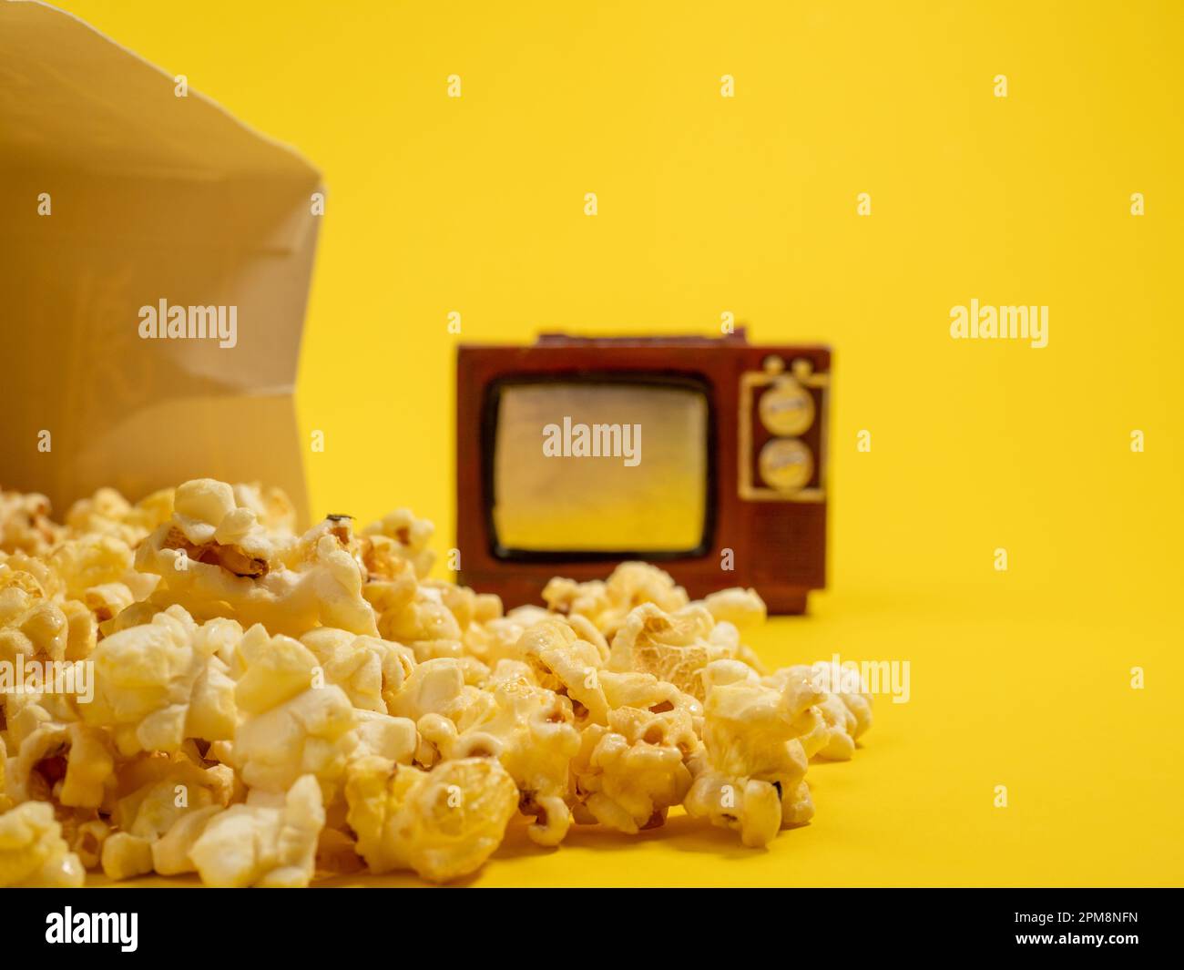 Popcorn and old TV on a yellow background. Sweet popcorn on yellow ...