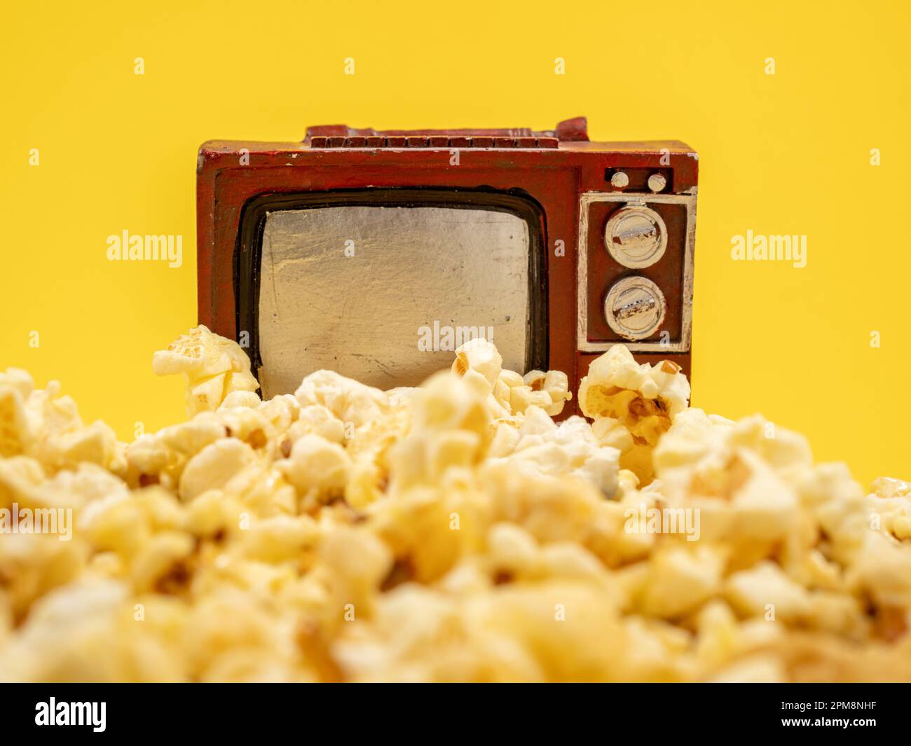 Popcorn and old TV on a yellow background. Sweet popcorn on yellow ...