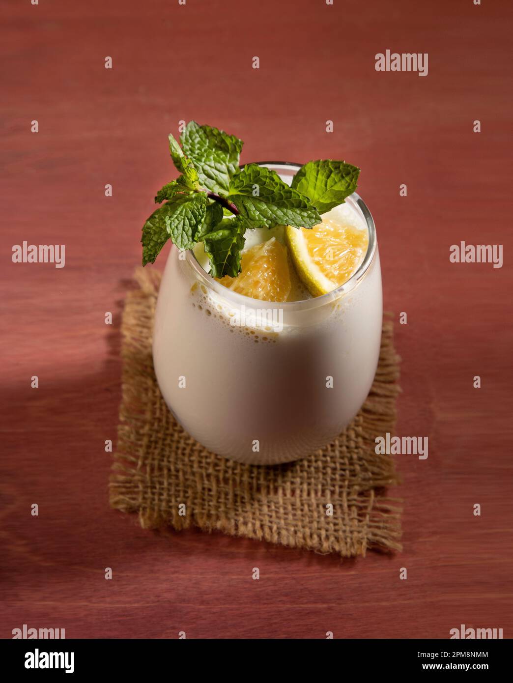 A vibrant image depicting a tall white cocktail glass with a few lemon ...