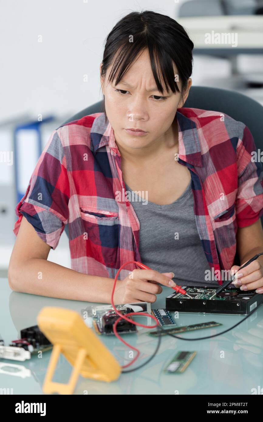 female technician using voltage meter on hard drive Stock Photo - Alamy