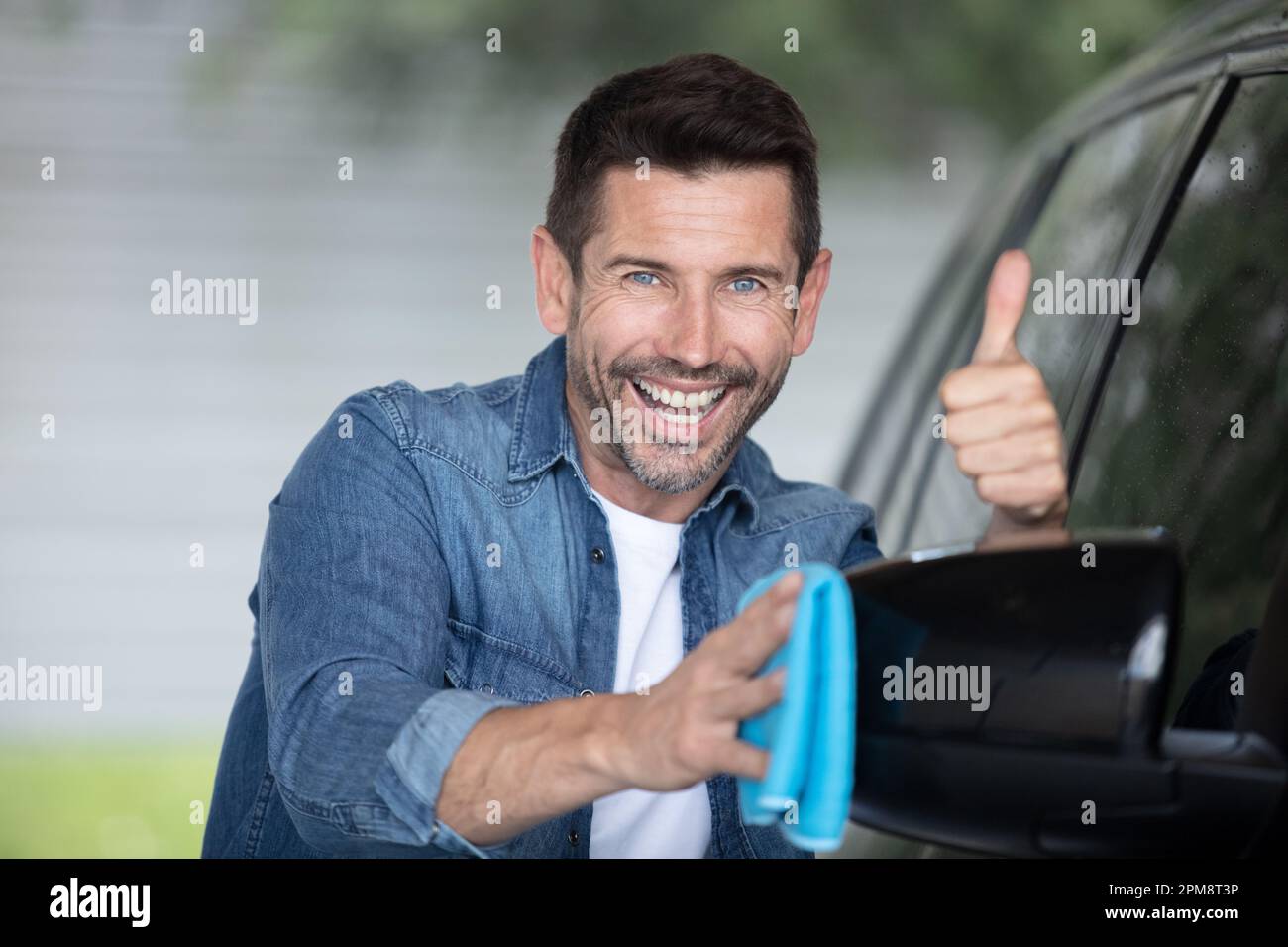 showing thumb up after polishing his car Stock Photo - Alamy