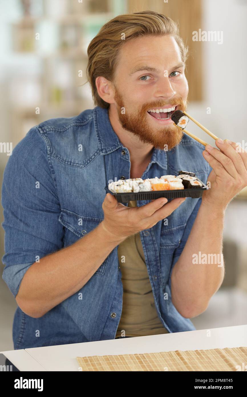 Happy man eating sushi hi-res stock photography and images - Alamy