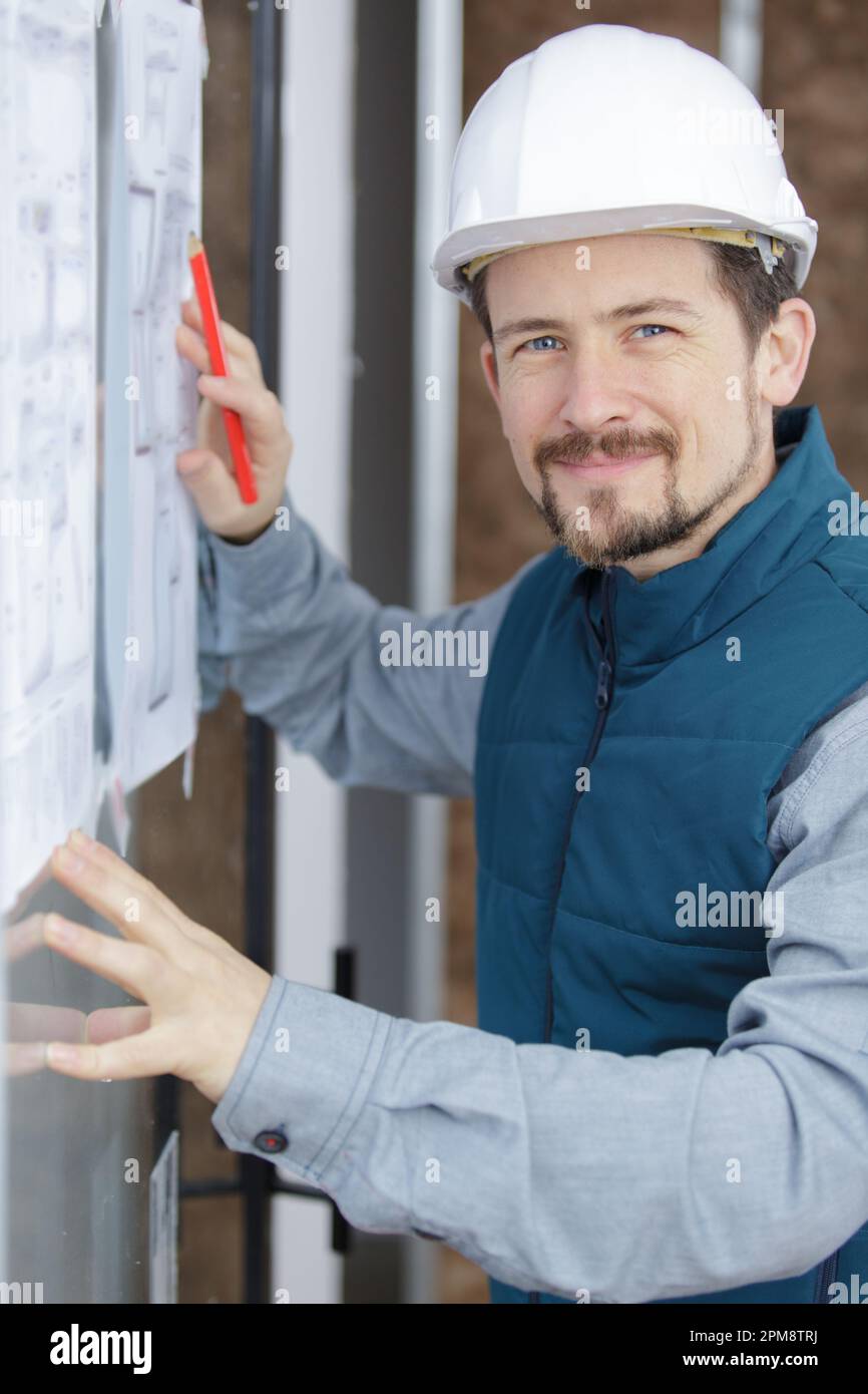 happy architect working on blueprint plans Stock Photo - Alamy