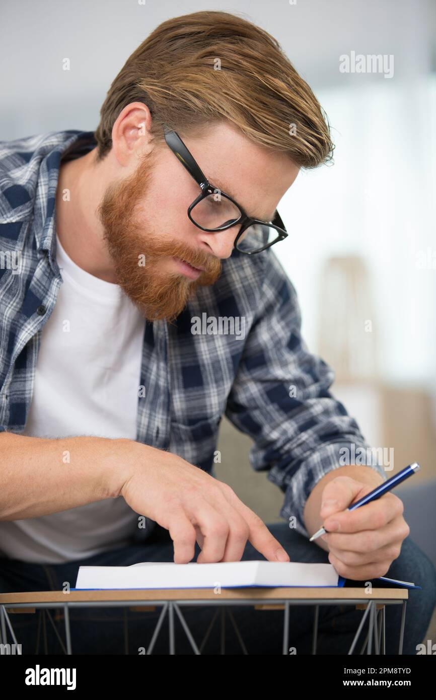 man writing note on a book Stock Photo - Alamy