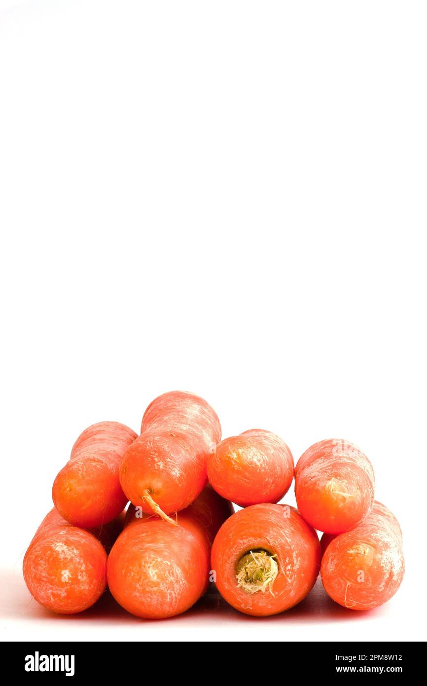 bunch of raw carrots on a white background Stock Photo - Alamy