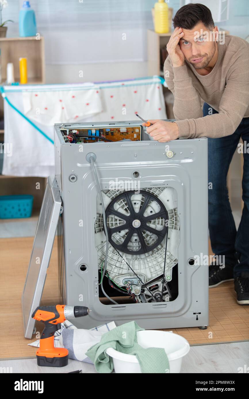 concept man stressed next to washing machine Stock Photo - Alamy
