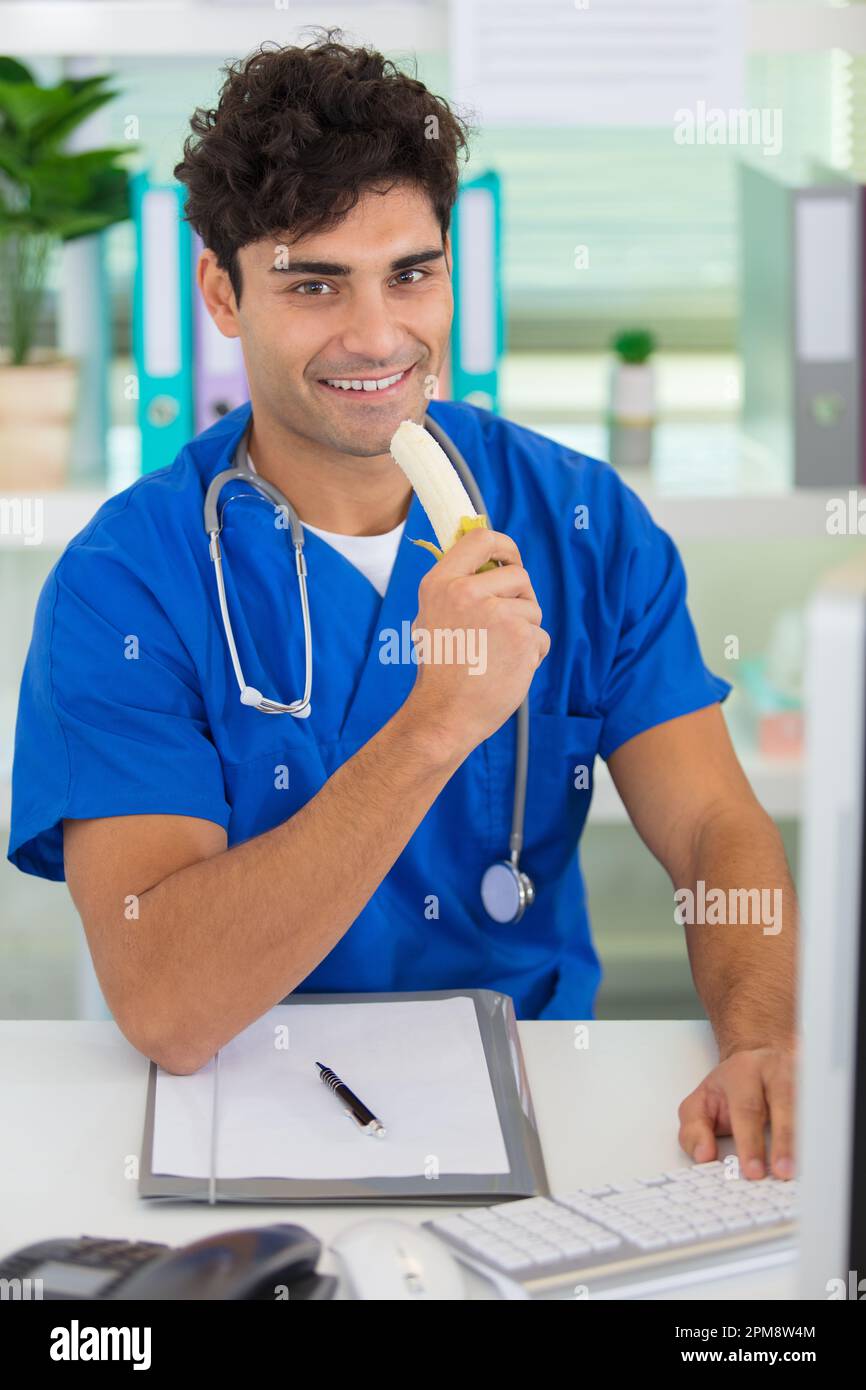 healthy doctor eating a banana at his office Stock Photo - Alamy