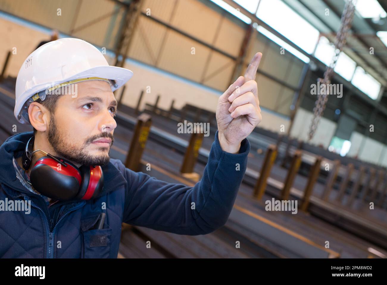 male worker in warehouse pointing upwards Stock Photo - Alamy