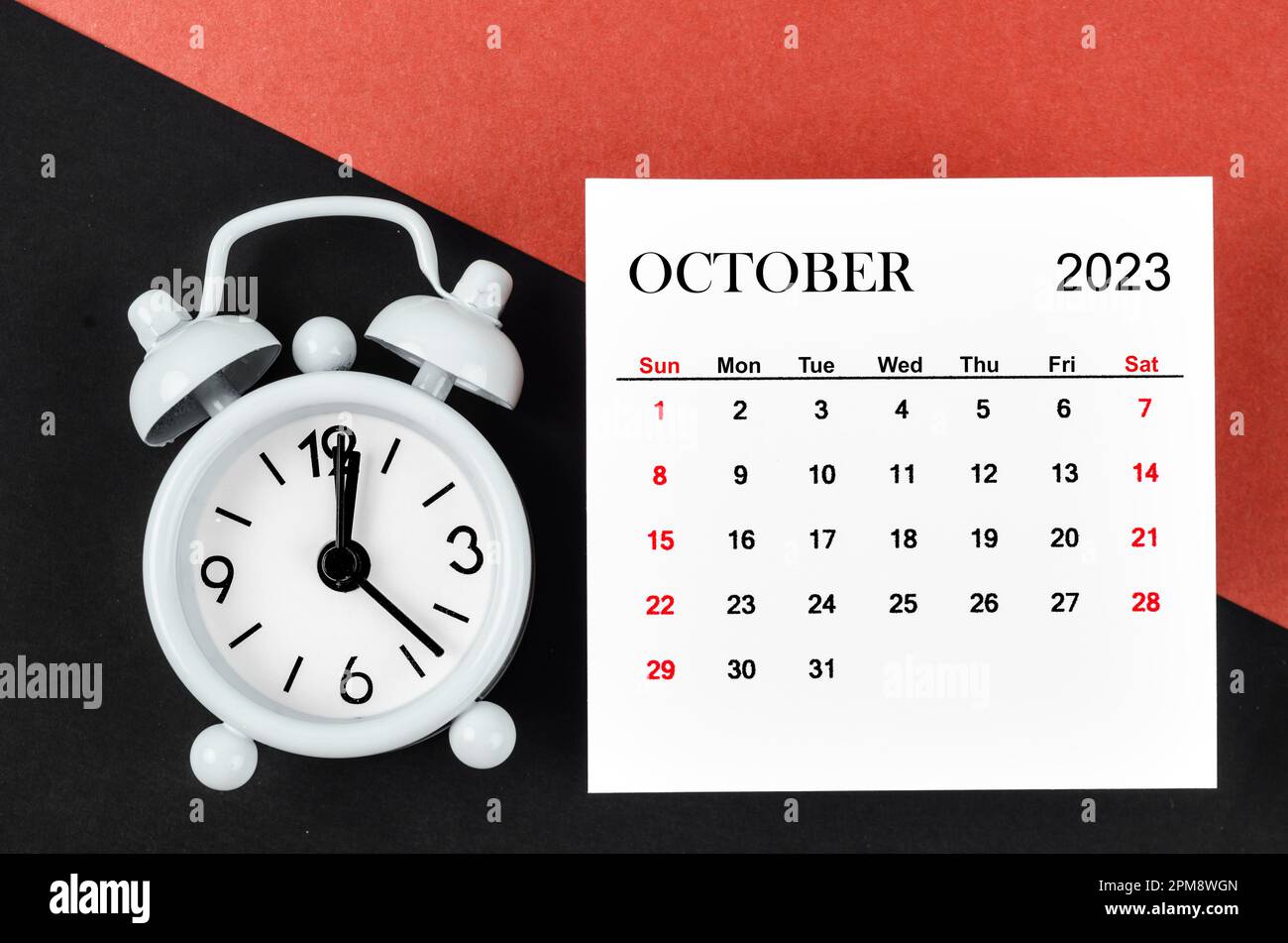 October 2023 Monthly calendar year with alarm clock on red and black ...