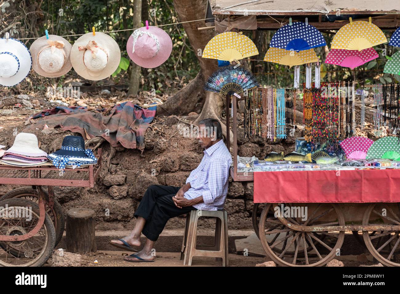 Old Goa, India - January 2023: An Indian street vendor selling hats and ...
