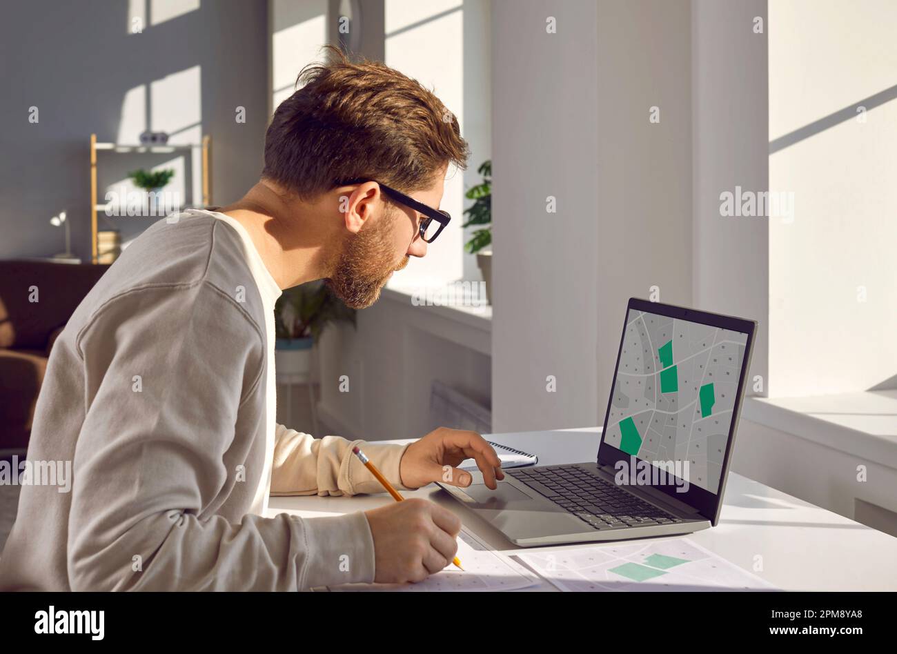 Professional cartographer working with cadastral map on a laptop on his ...