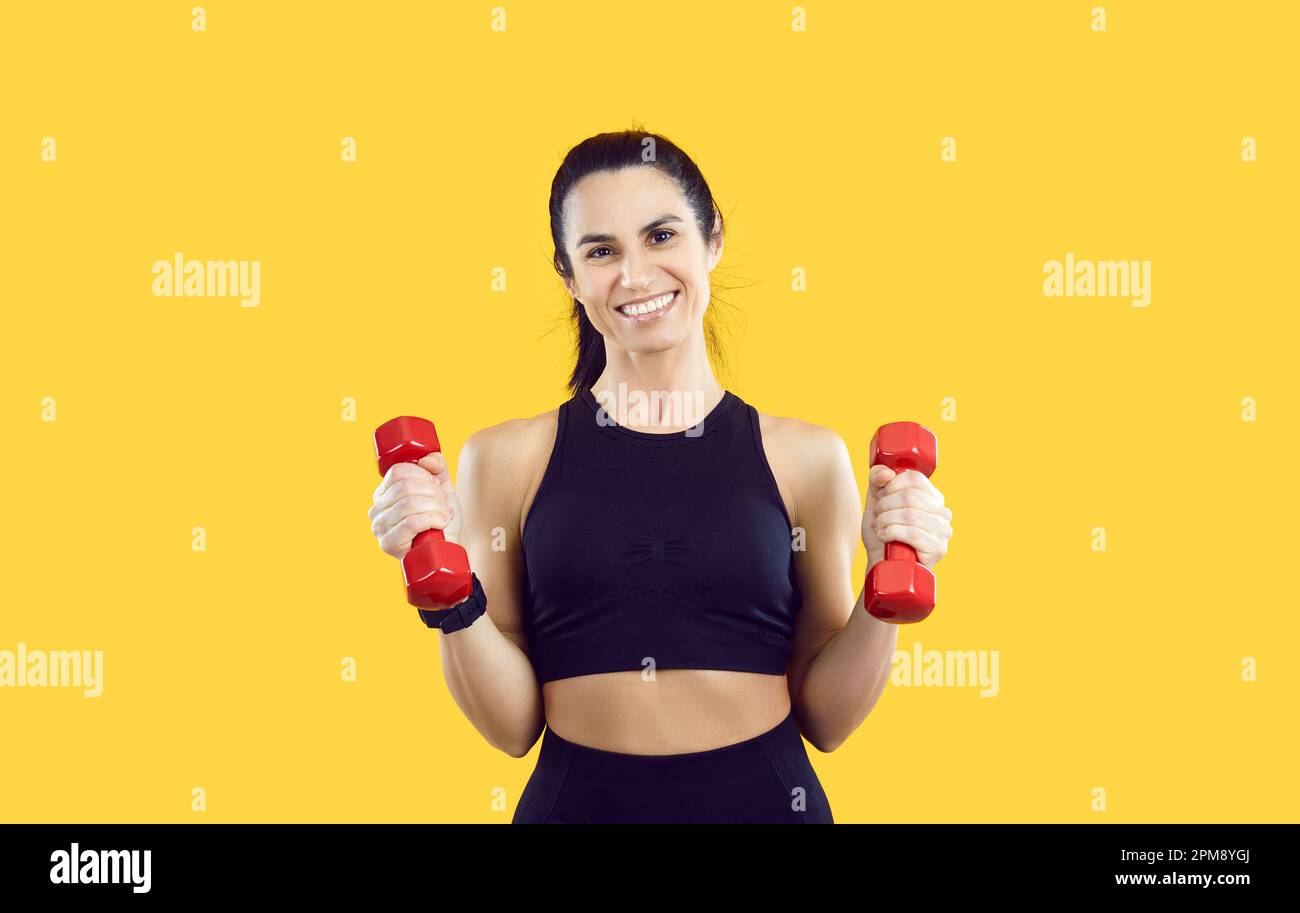 Portrait of friendly beautiful female personal fitness trainer on vivid ...