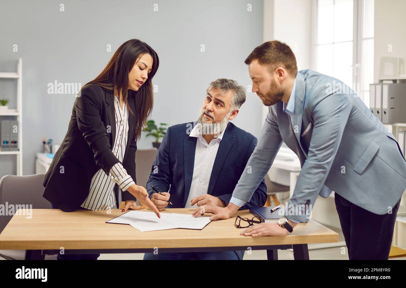 Confident man signing some documents at the office reaching agreement ...