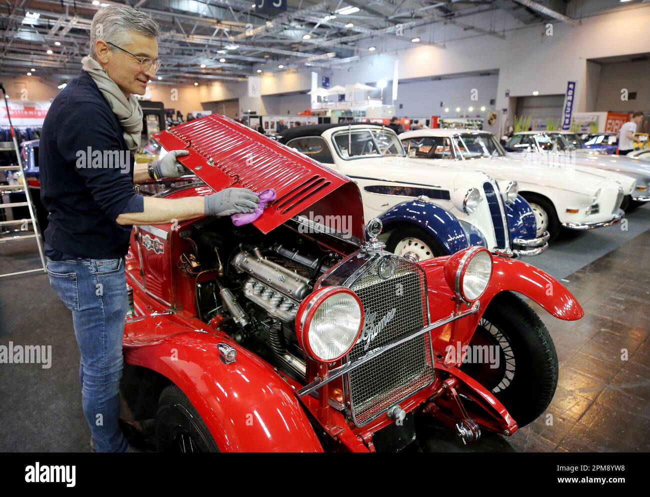 Essen, Germany. 12th Apr, 2023. A booth employee polishes a 1930 Alfa ...