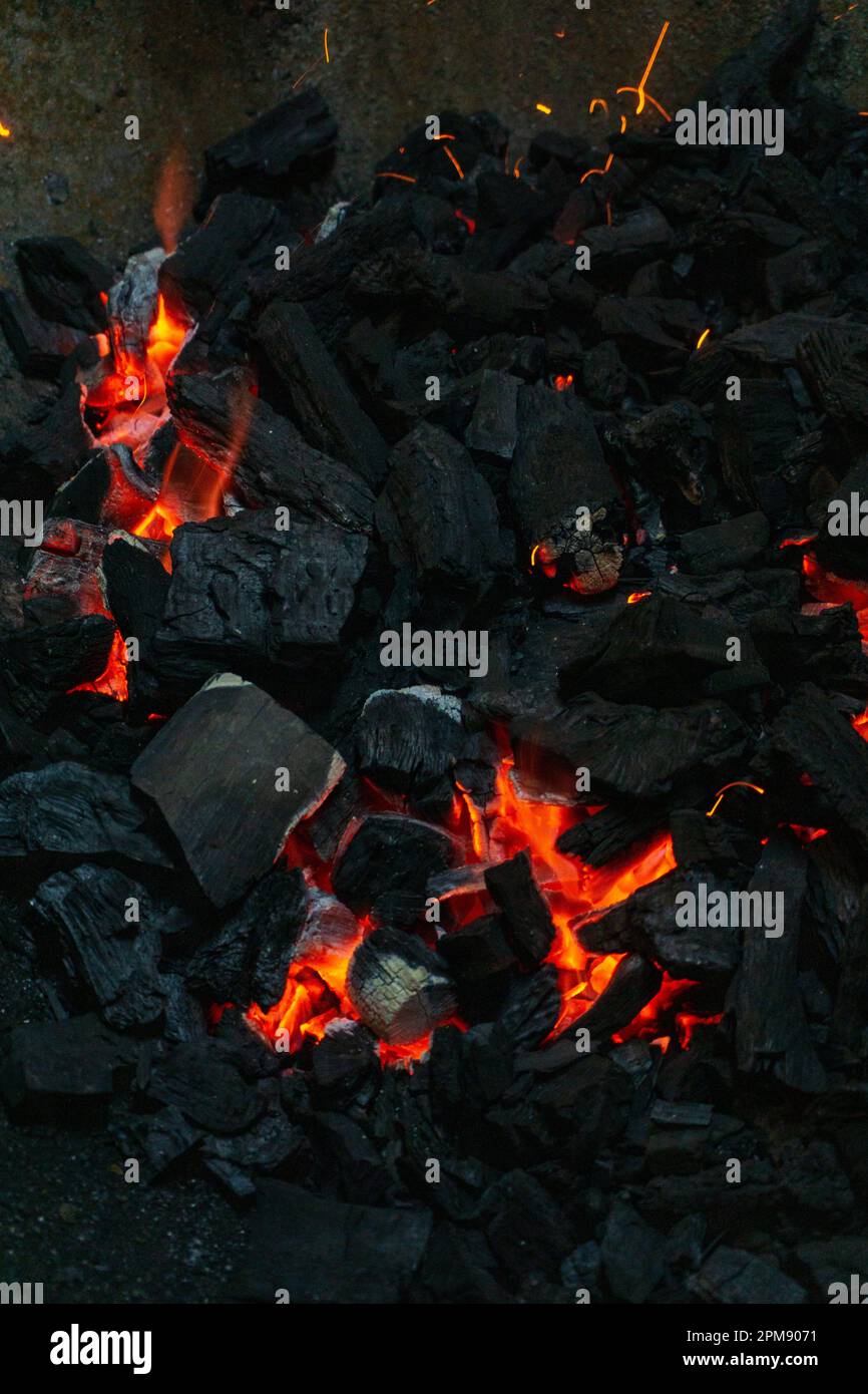 Coals with sparks in a huge old metal grill background Stock Photo - Alamy