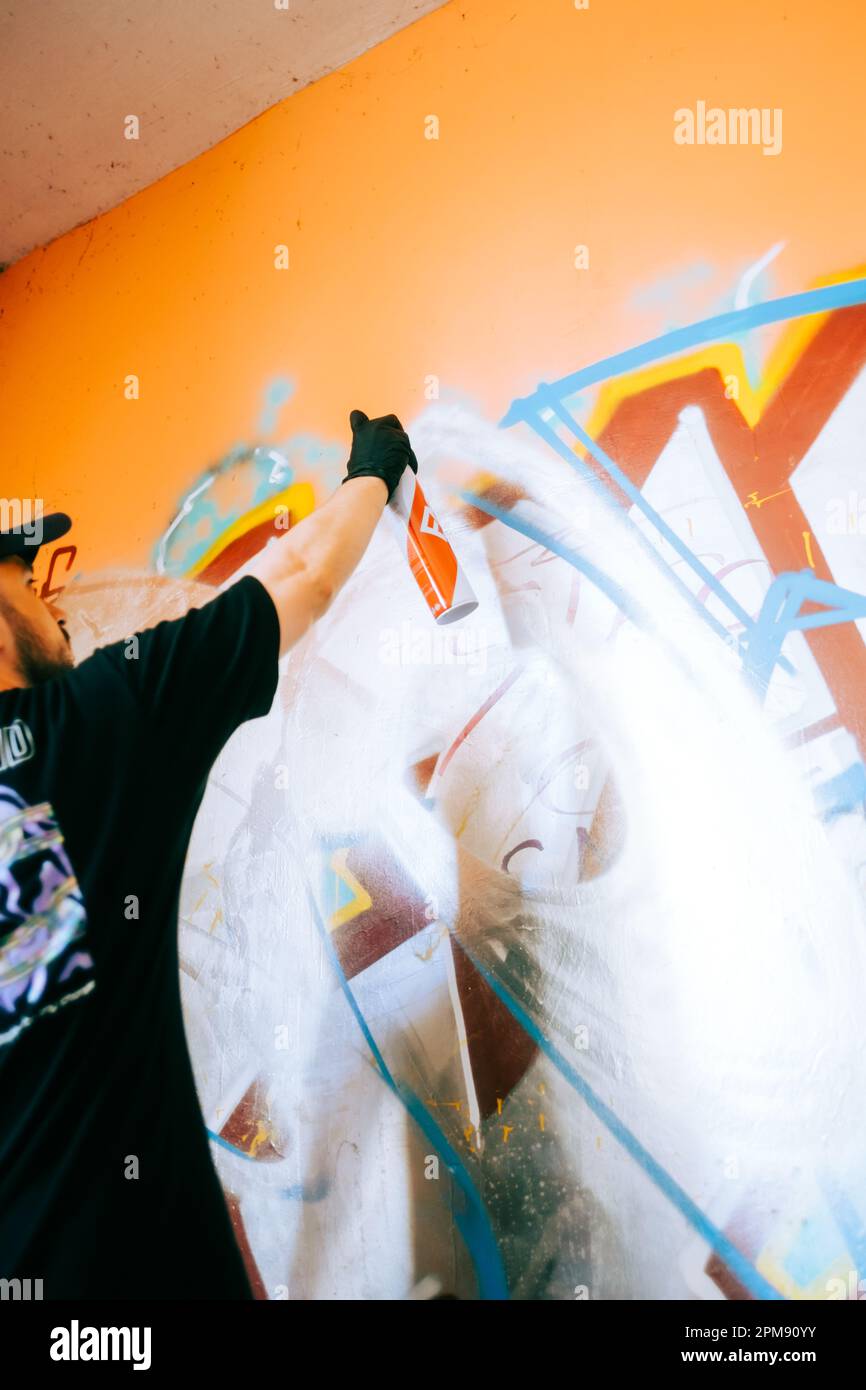 Young caucasian man graffiti artist drawing on a wall Stock Photo - Alamy