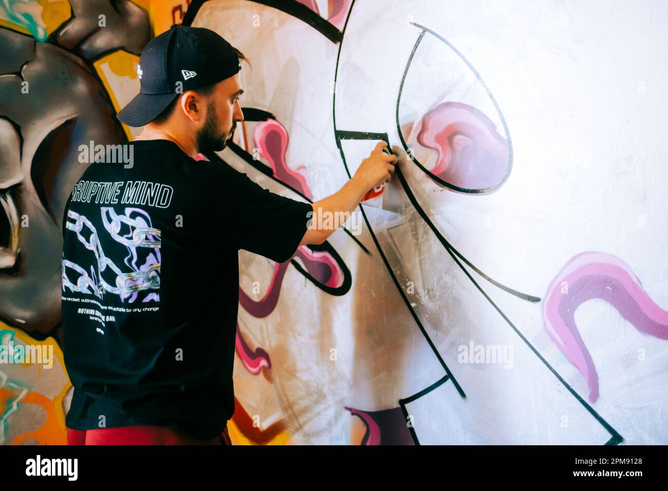 Young caucasian man graffiti artist drawing on a wall Stock Photo - Alamy