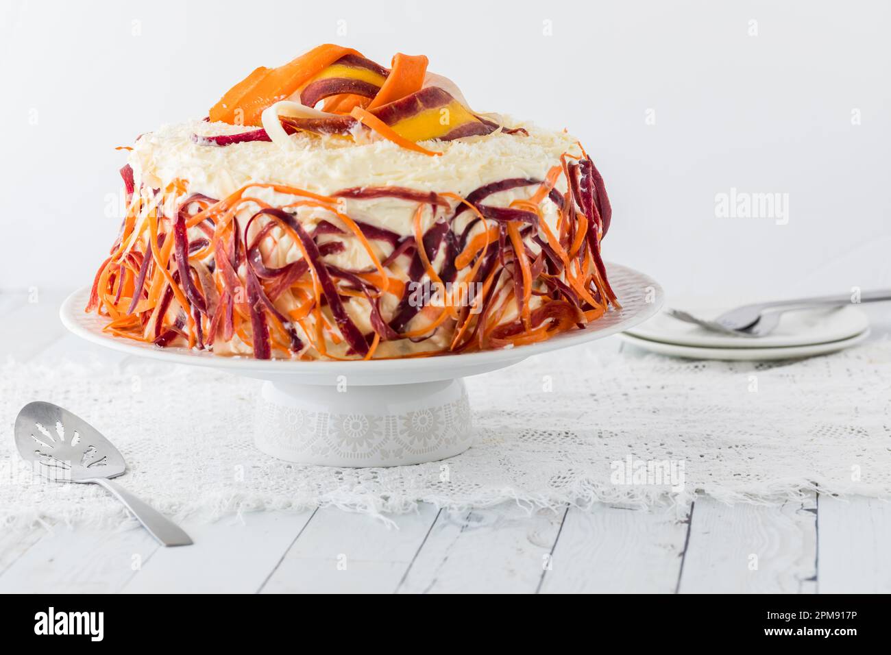 A colourful carrot cake garnished with rainbow carrot shavings Stock ...