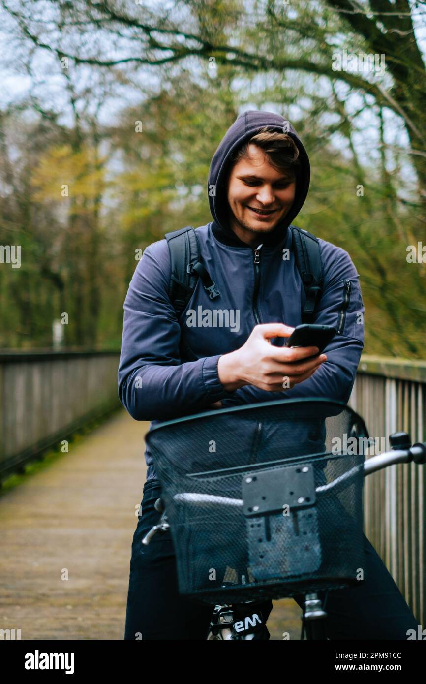 Young caucasian man cyclist ride on bicycle in the park and using ...