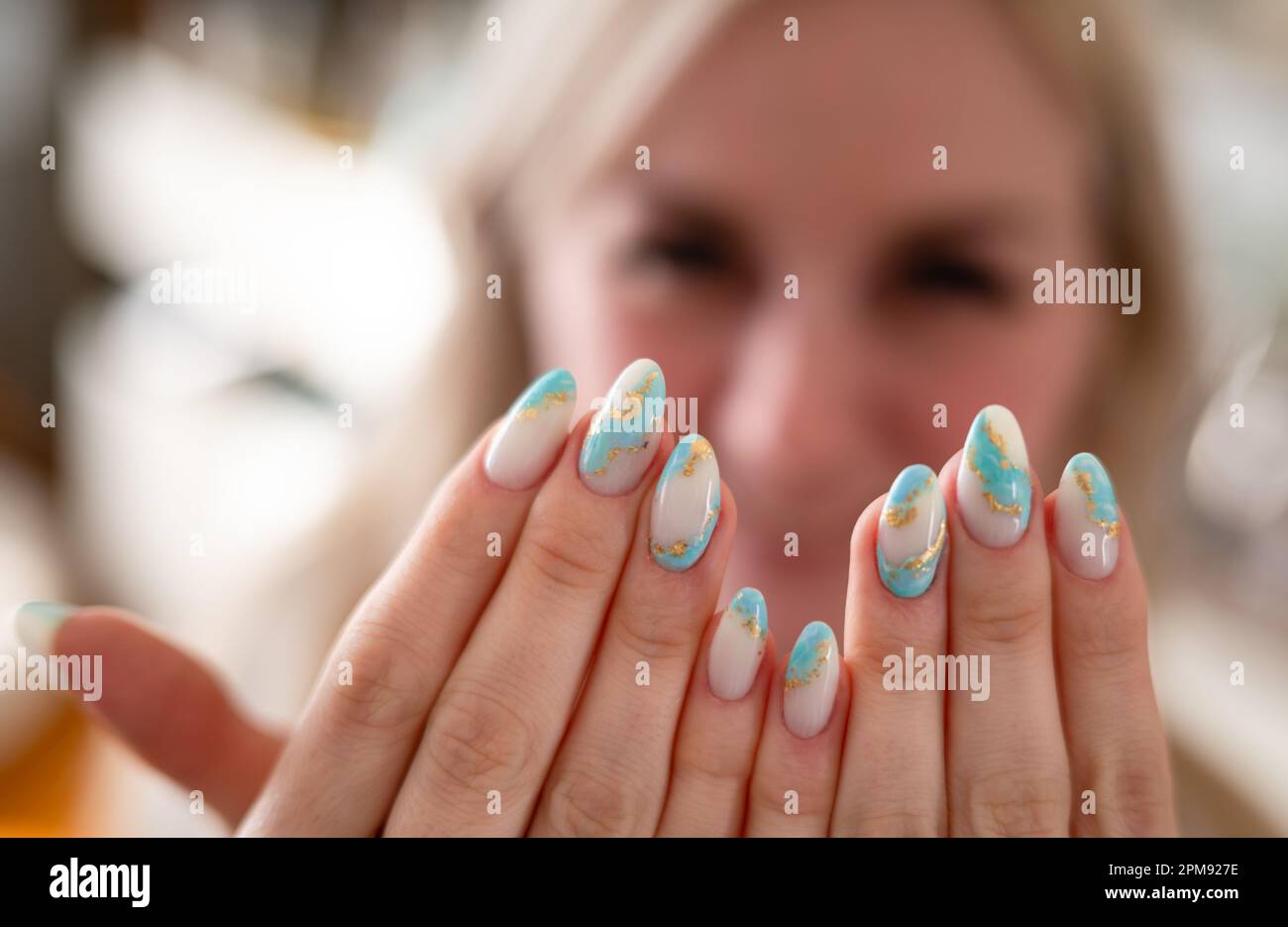 Pretty fingernails after manicure with smiling blond woman in ...
