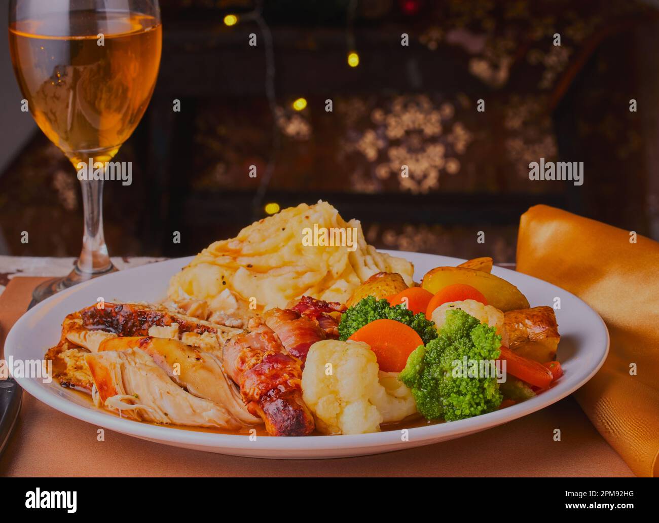 Christmas chicken,turkey dinner with a glass of wine with lights in the ...