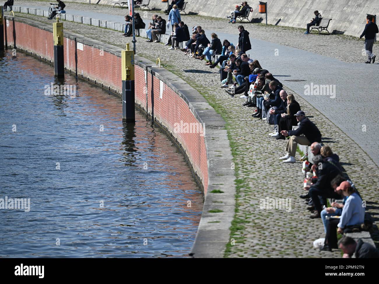 Berlin, Germany. 12th Apr, 2023. People sit on the banks of the Spree ...