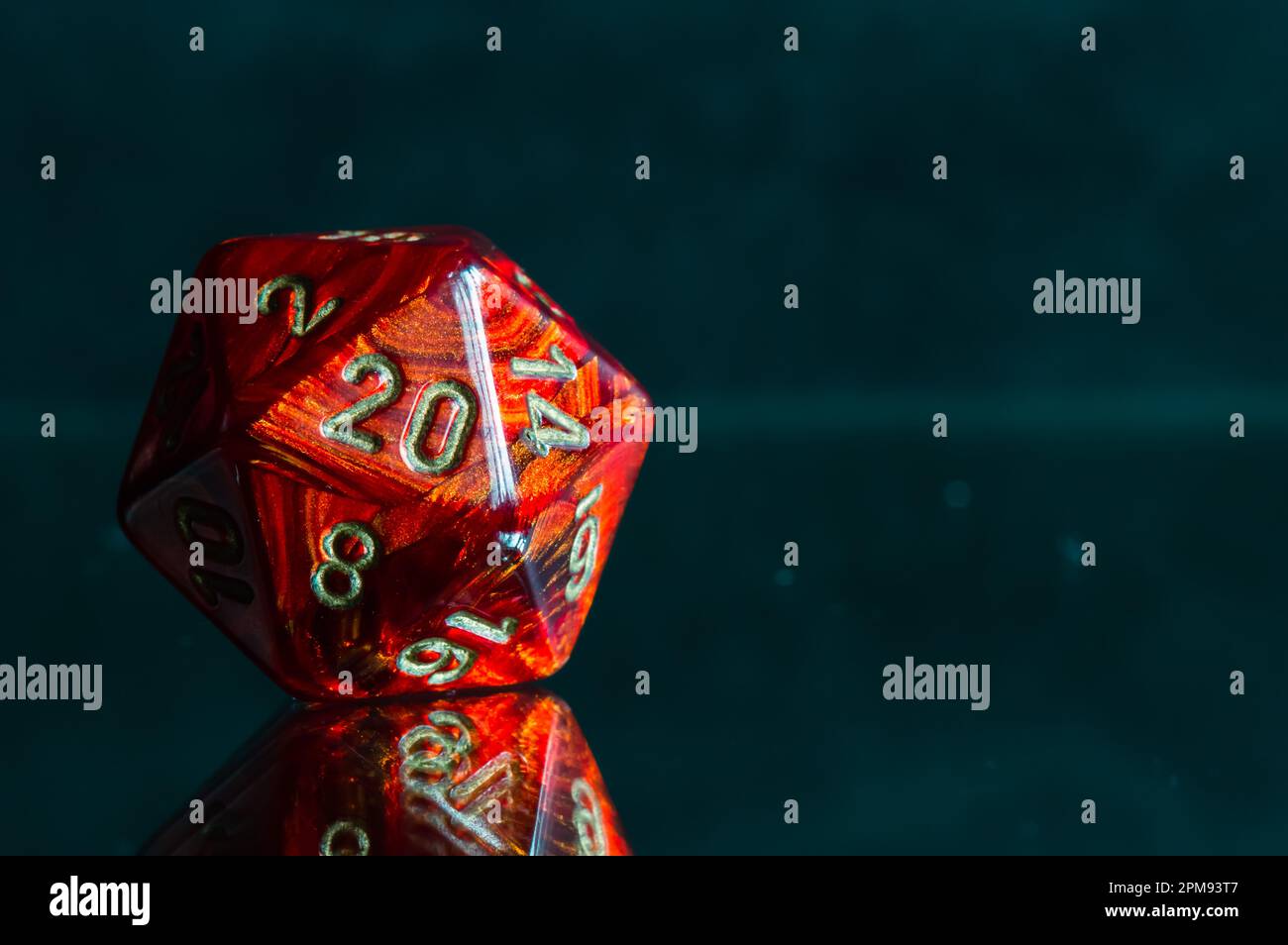 Close-up image of a red 20-sided Role-Playing dice on a reflective ...
