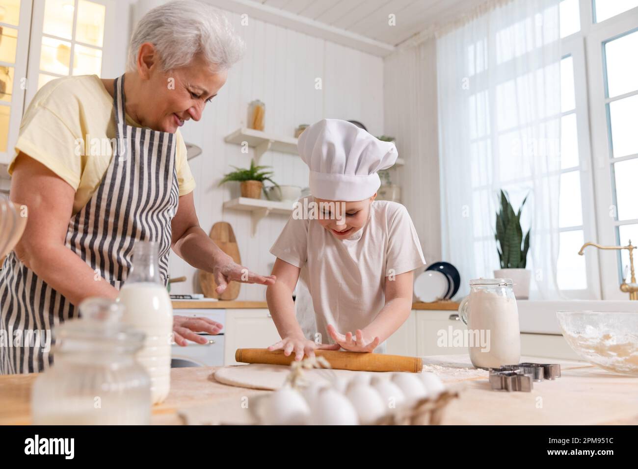 Happy family in kitchen. Grandmother and granddaughter child cook in ...