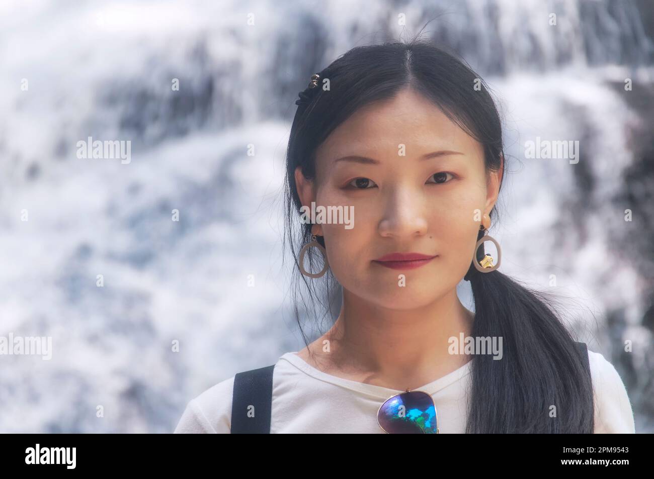 a happy chinese woman standing in front of Dingmans falls in Dingsman ...