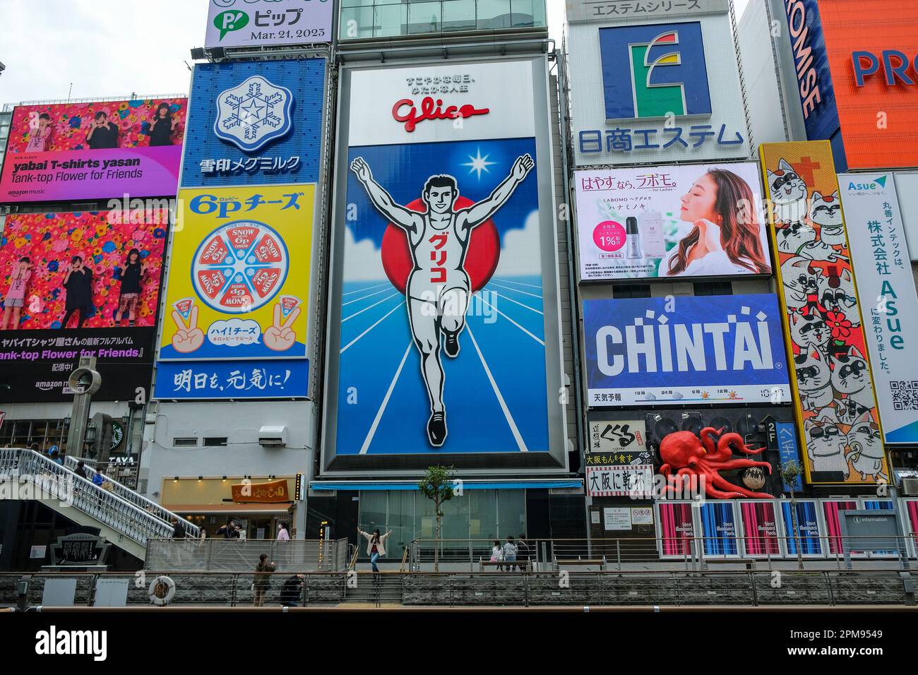 Osaka, Japan - March 21, 2023: Tourists taking photos in front of the famous Glico Man ...