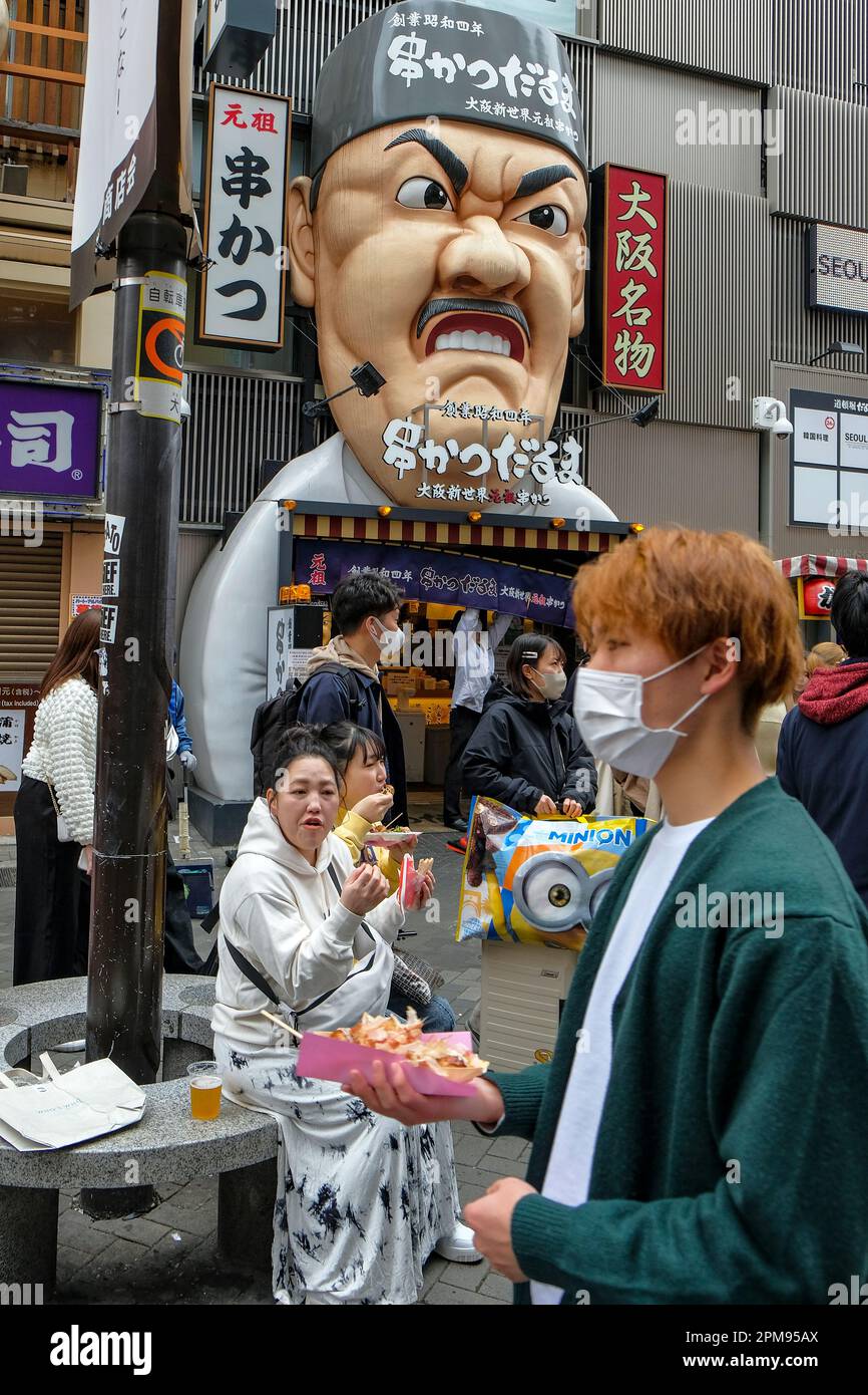 Osaka, Japan - March 21, 2023: People eating street food in the ...