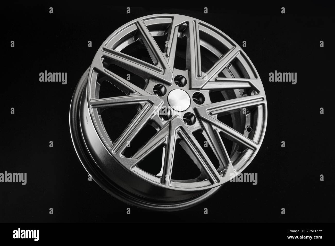 Grey multi-spoke alloy wheel on black background Stock Photo - Alamy