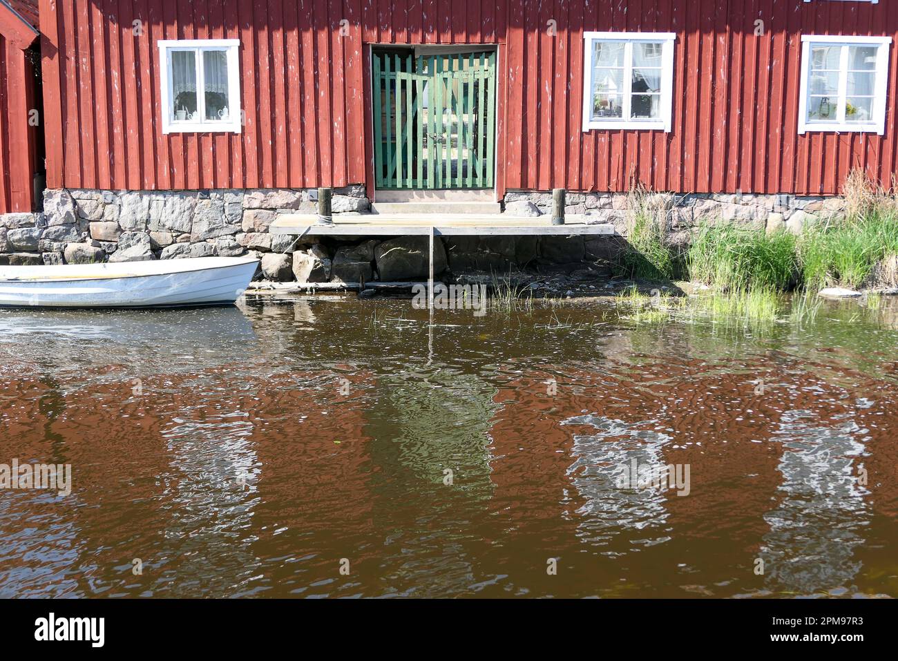 Red wooden building next to river during summer Stock Photo - Alamy