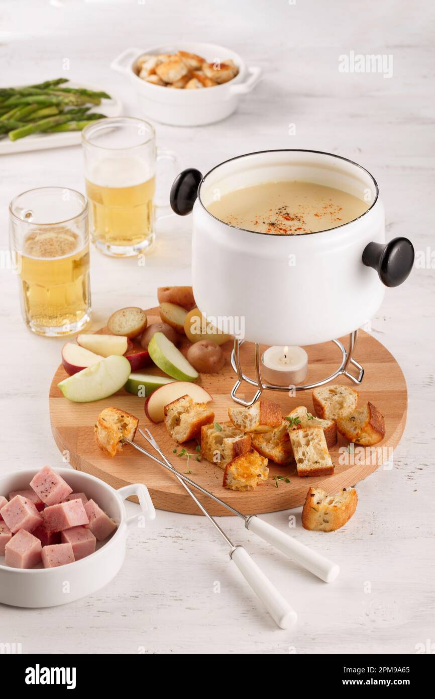 Comforting Swiss cheese fondue with vegetables and bread Stock Photo ...