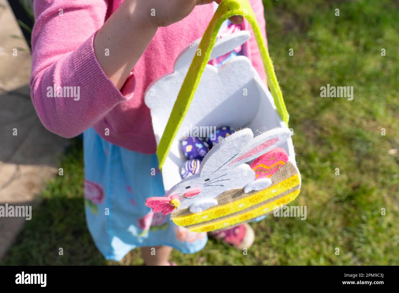 A young girl seven years old holding a basket with an Easter bunny on ...