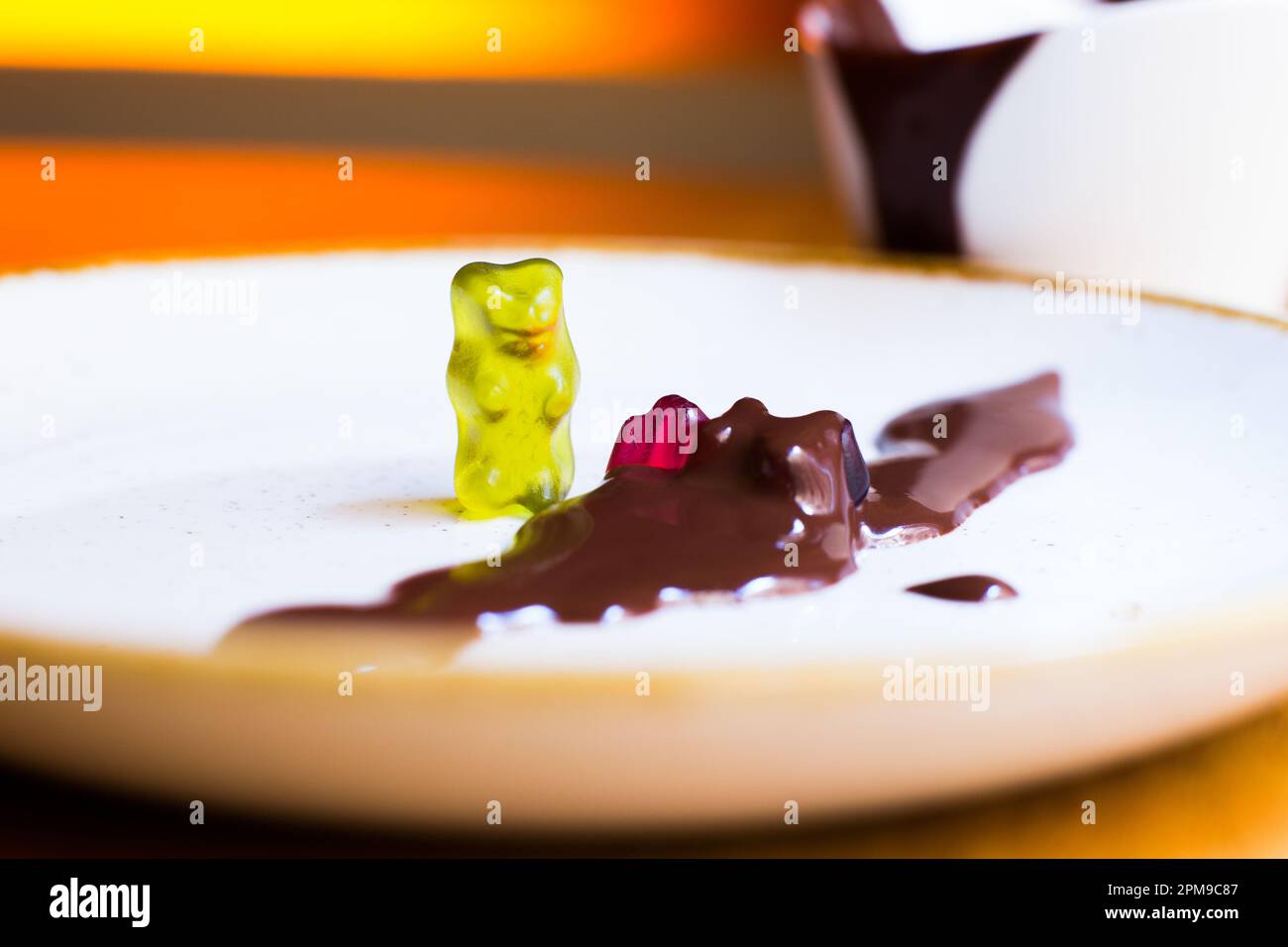 Gummy bears playing on a food table with chocolate sauce Stock Photo ...