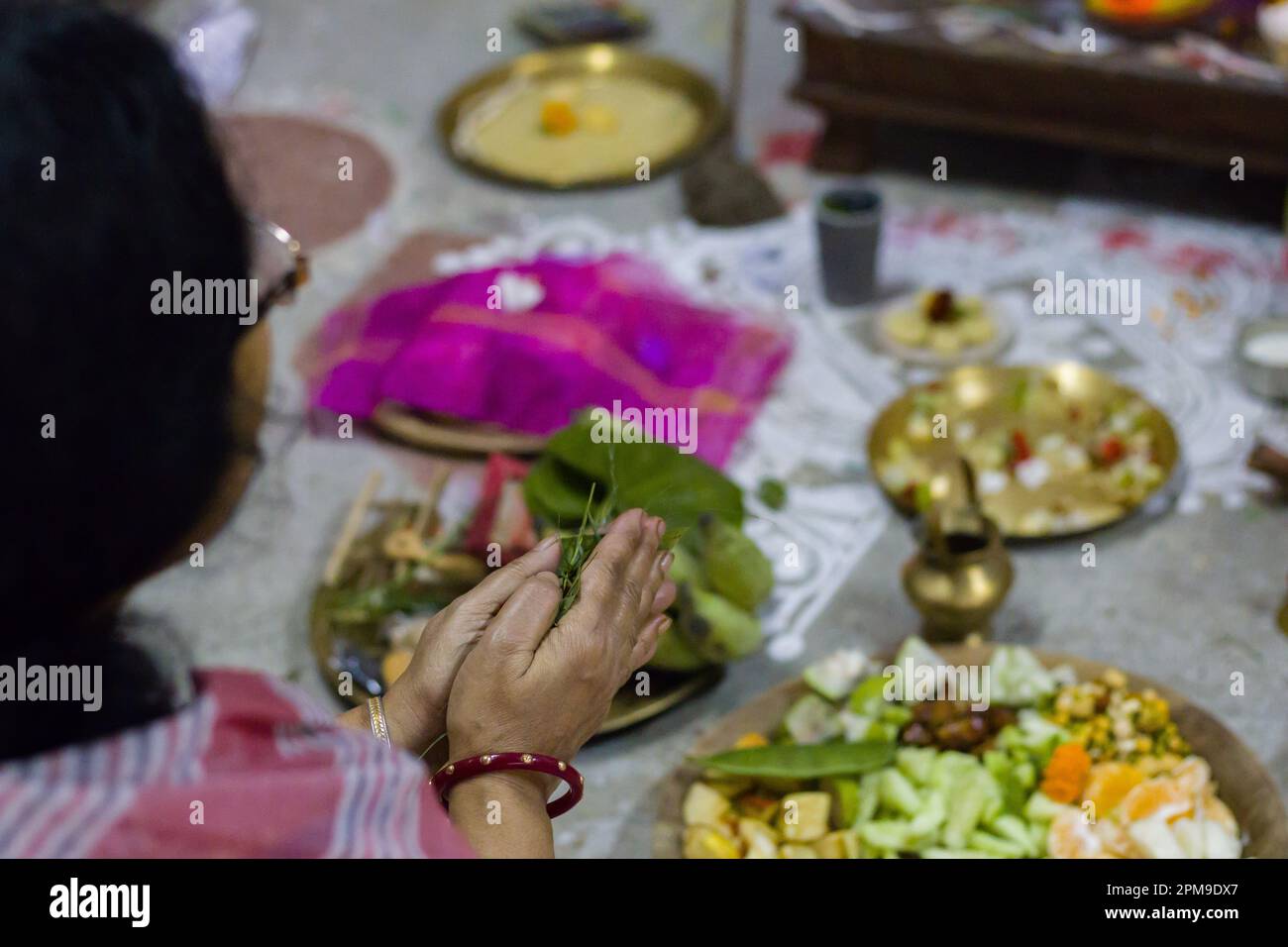 Traditional Indian woman worshipping god with folded hands during ...