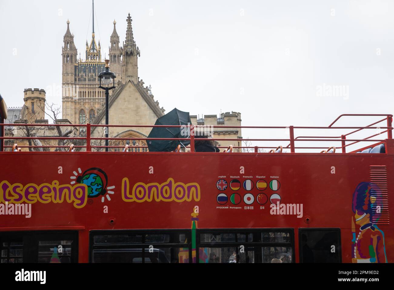 An umbrella blows inside out on a sightseeing bus in Westminster London ...