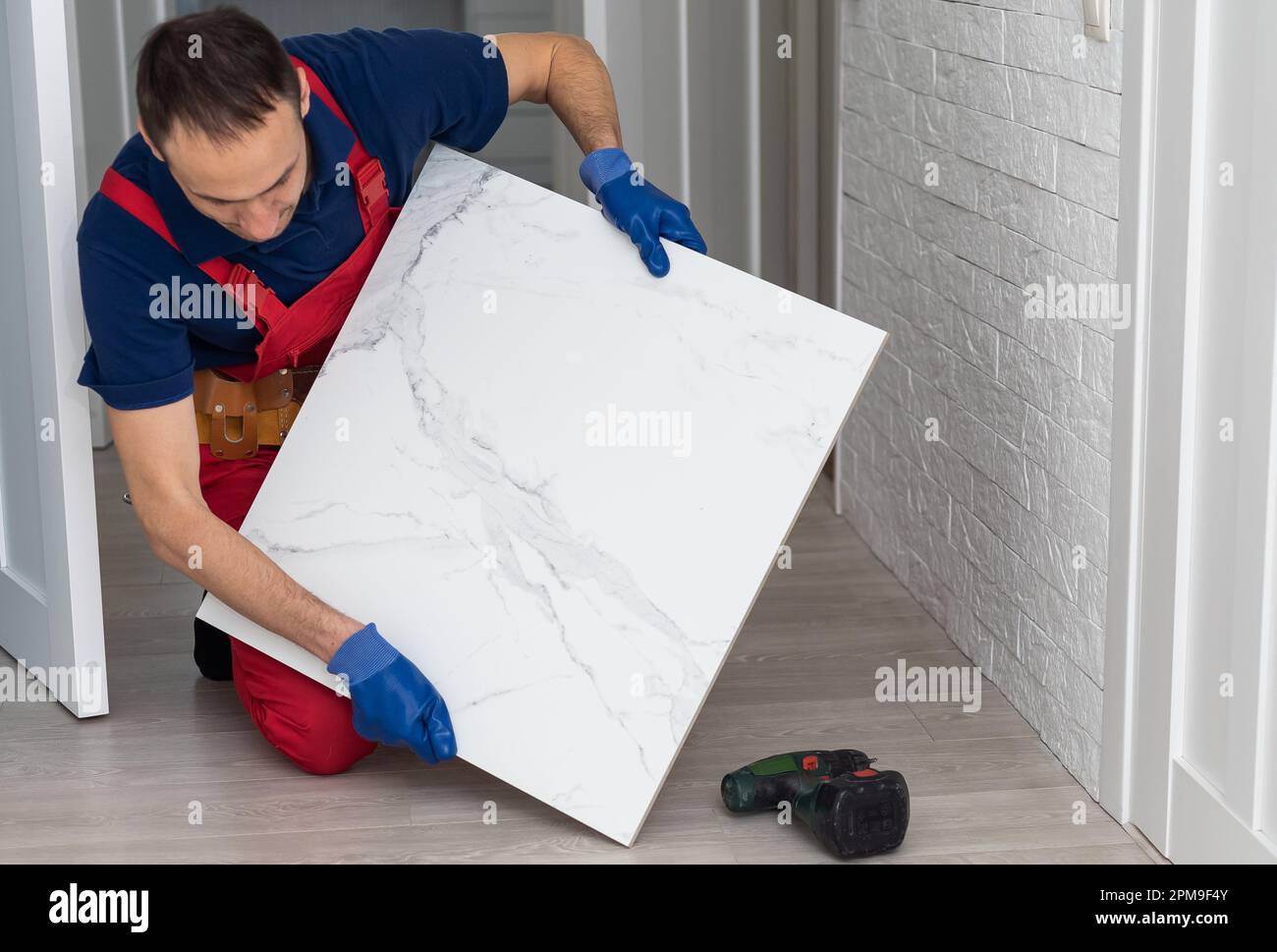 Home improvement, renovation - construction worker tiler is tiling ...