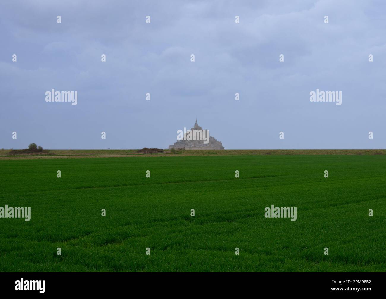 Mont Saint Michel from afar with green farmland in foreground, Normandy ...