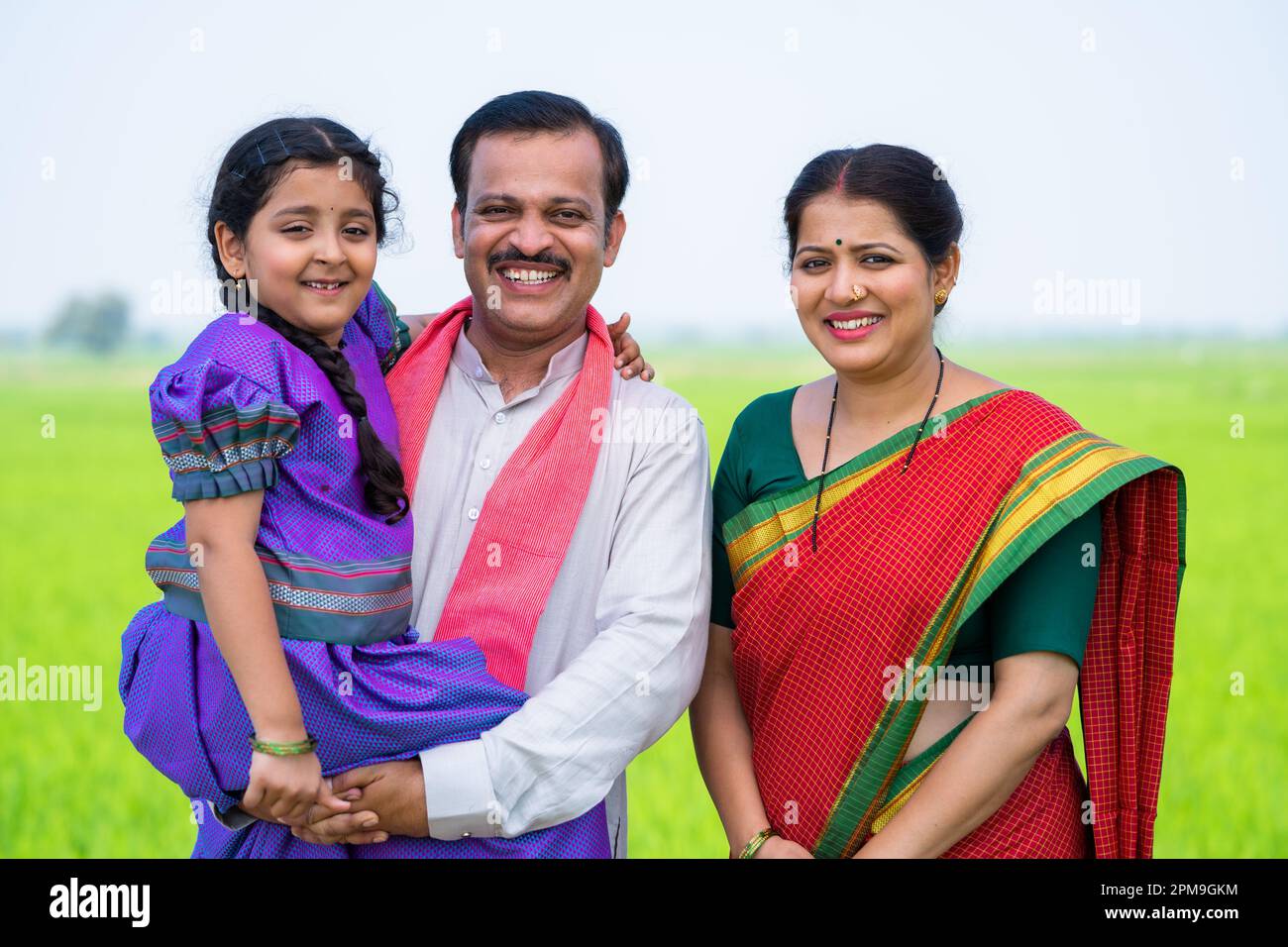 Portrait shot of Happy smiling Indian village farming couple with kid ...