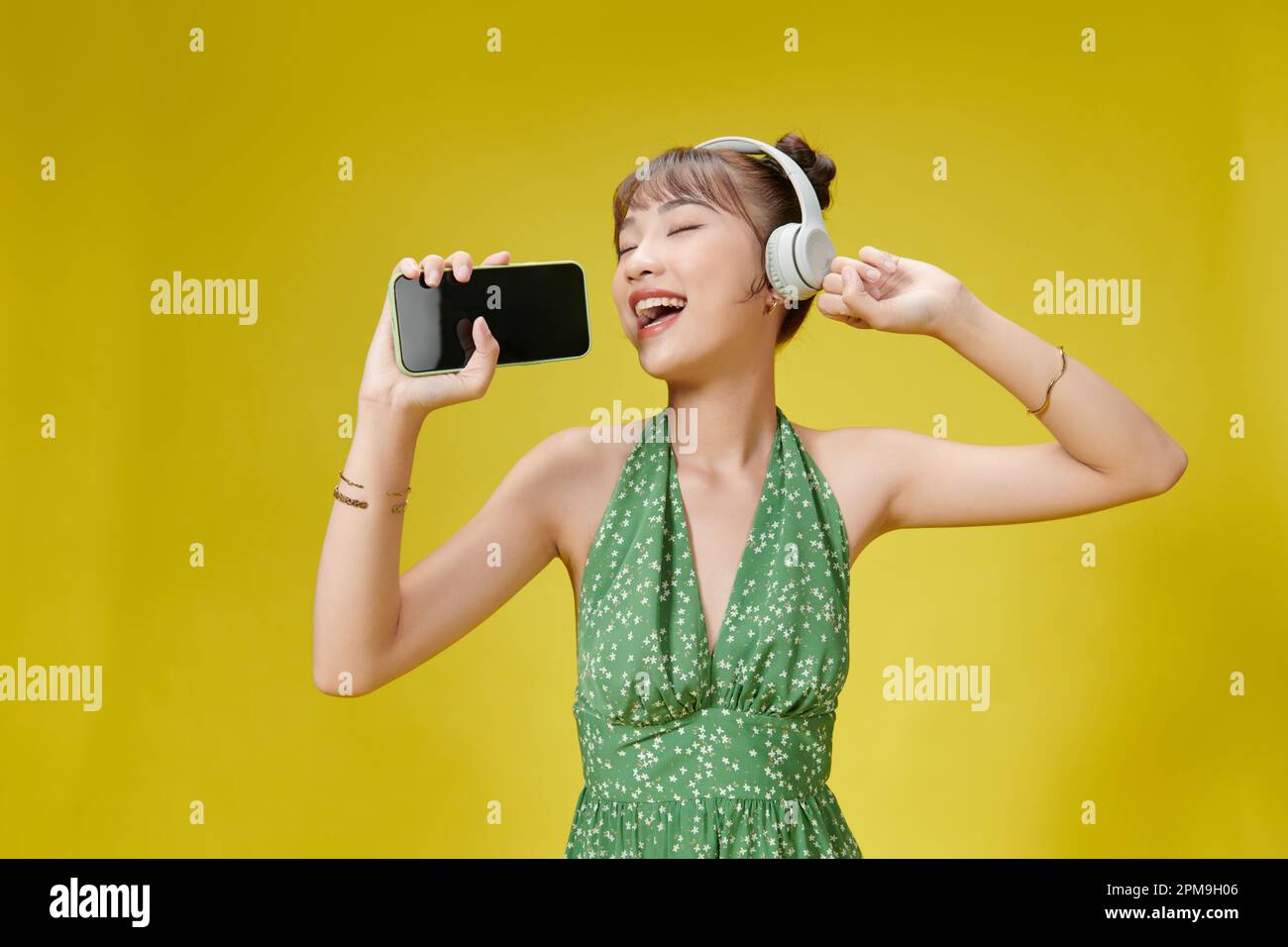 Portrait of excited overjoyed attractive girl hold telephone sing have ...