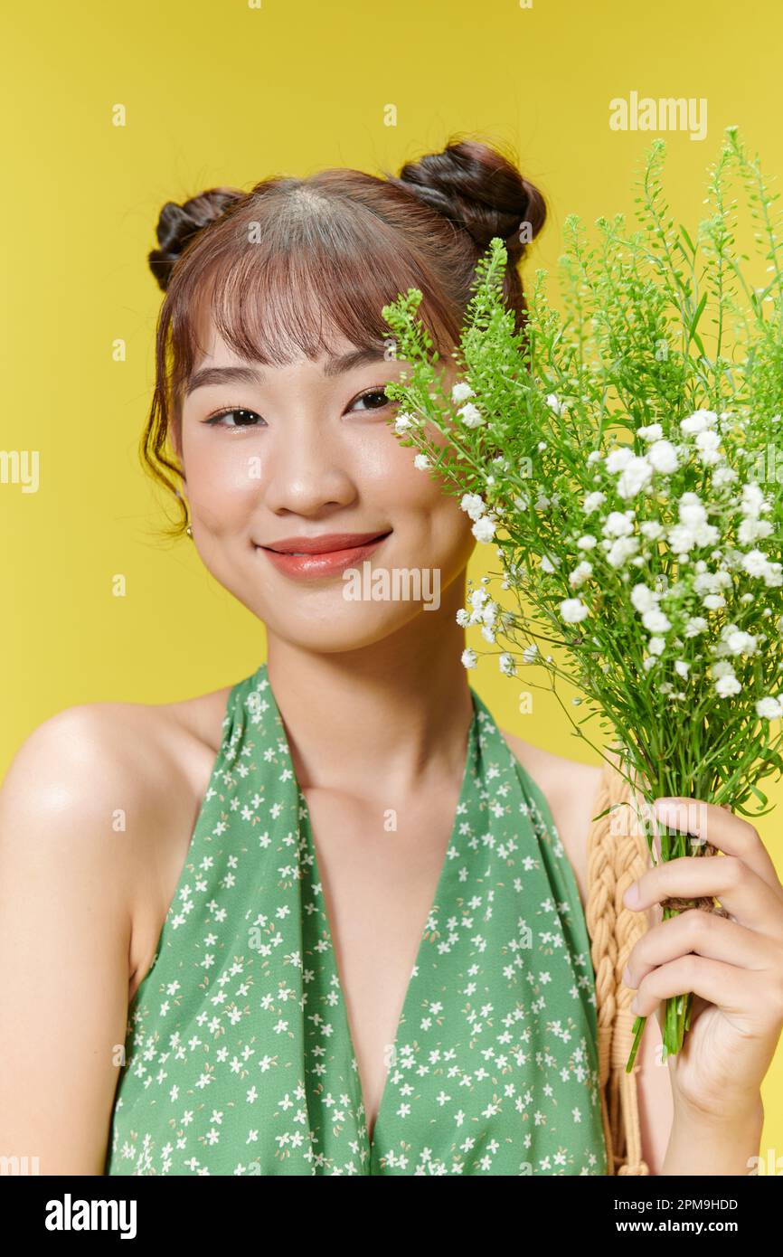 Happy woman in polka dot outfit laughing and holding flowers Stock ...