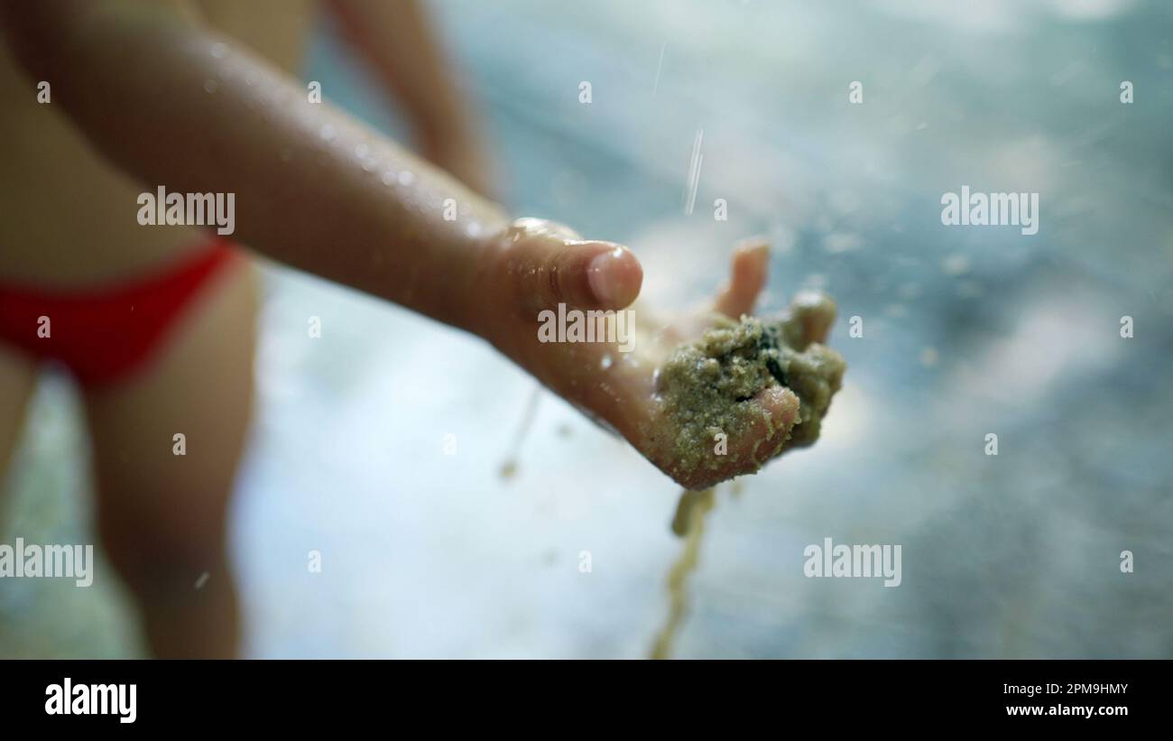 Small child washing hands outside in public water park. Kid hand cleaning mud and sand from hand ...